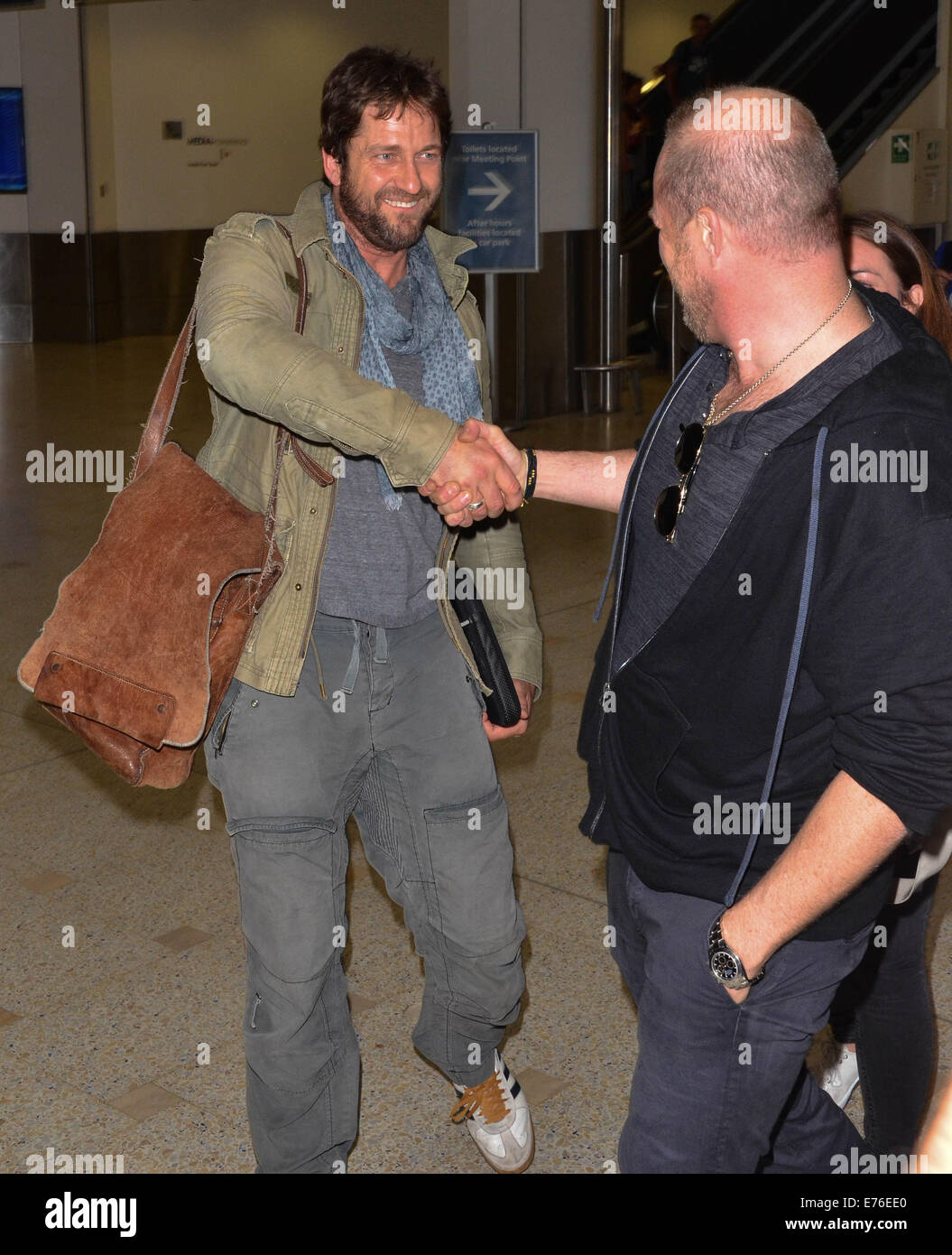 Gerard Butler wearing a light olive green jacket and cargo trousers ...