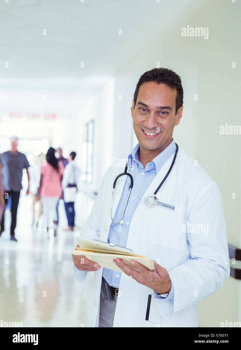 Doctor reading medical chart in hospital hallway Stock Photo - Alamy