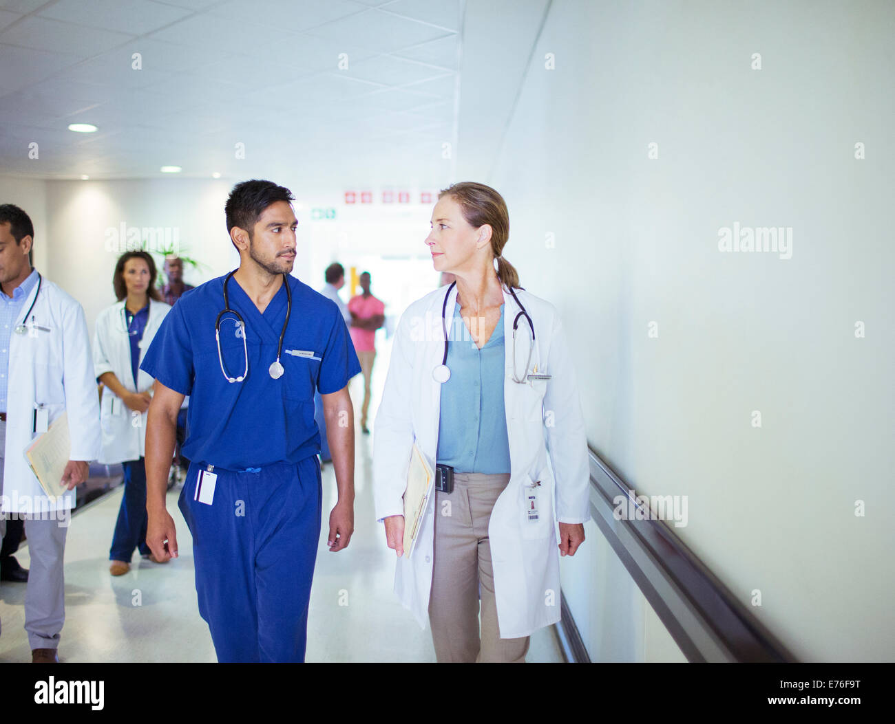 Doctor and nurse talking in hospital hallway Stock Photo - Alamy