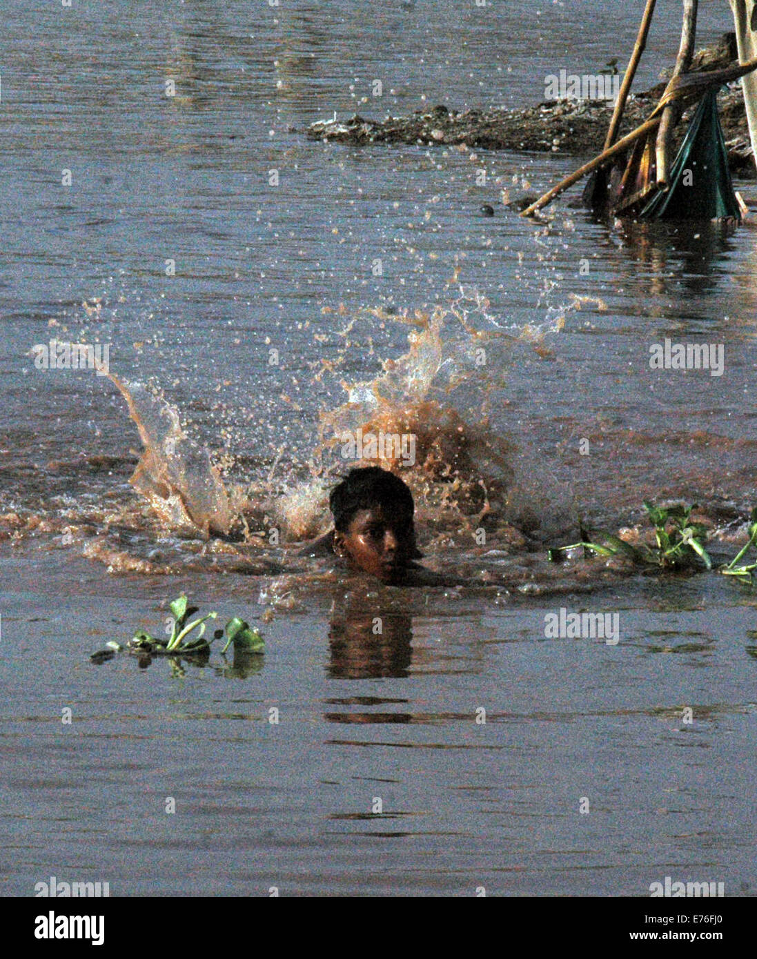 Lahore, Pakistan. 8th Sep, 2014. A Pakistani boy swims in the flooded ...