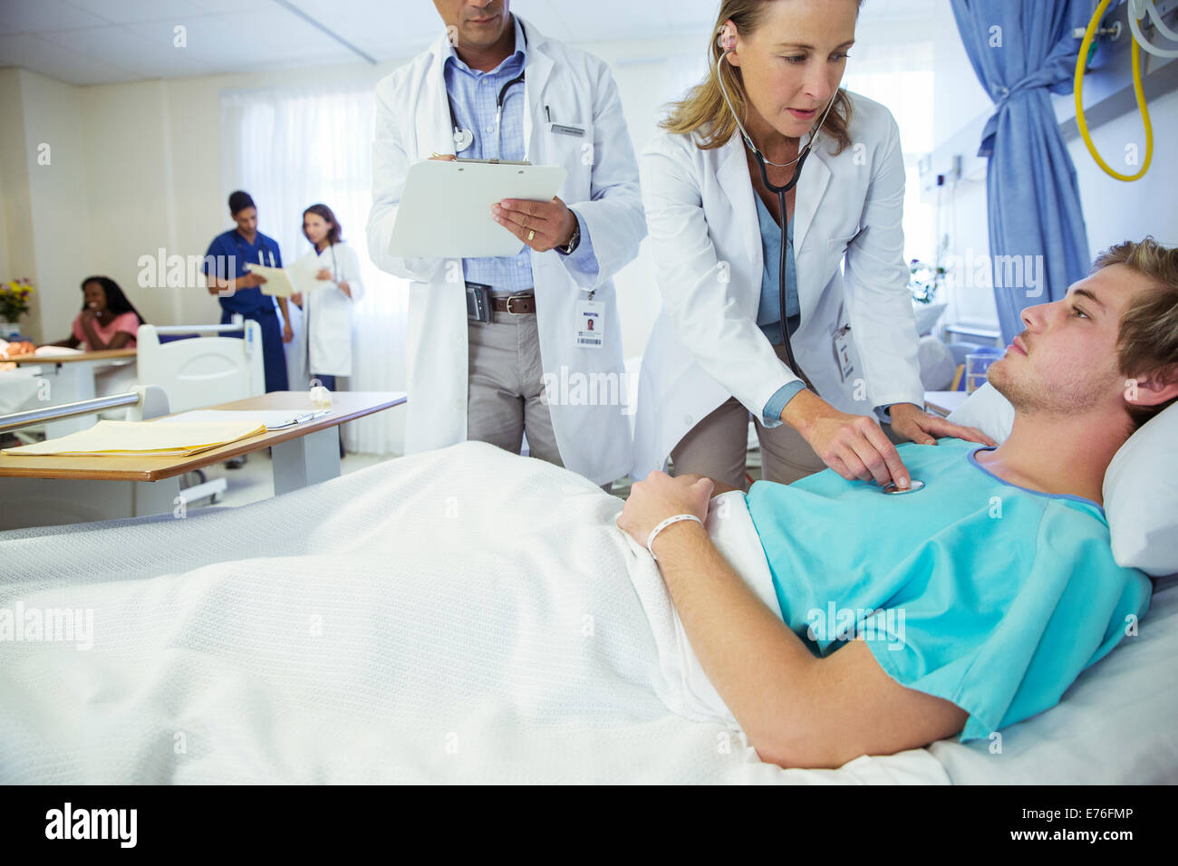 Doctors examining patient in hospital room Stock Photo - Alamy