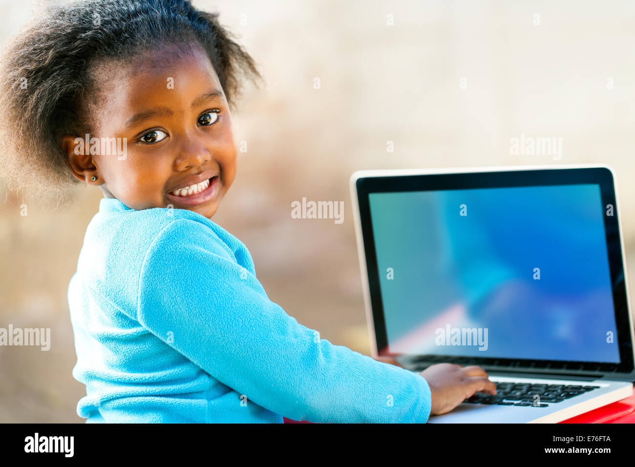 Cute African student working on laptop showing blank screen with copy ...