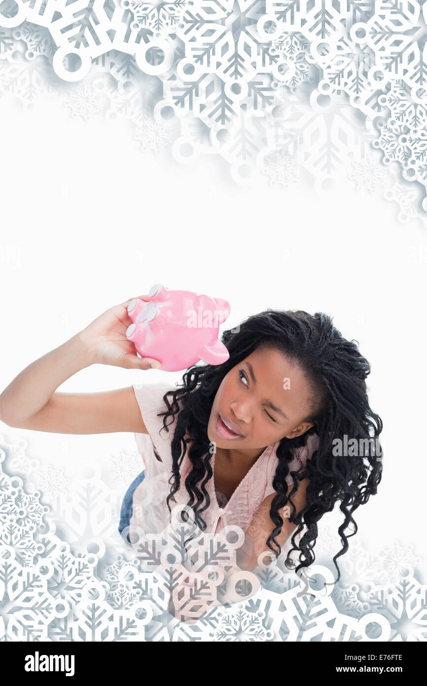Composite image of woman looking inside her piggy bank Stock Photo - Alamy