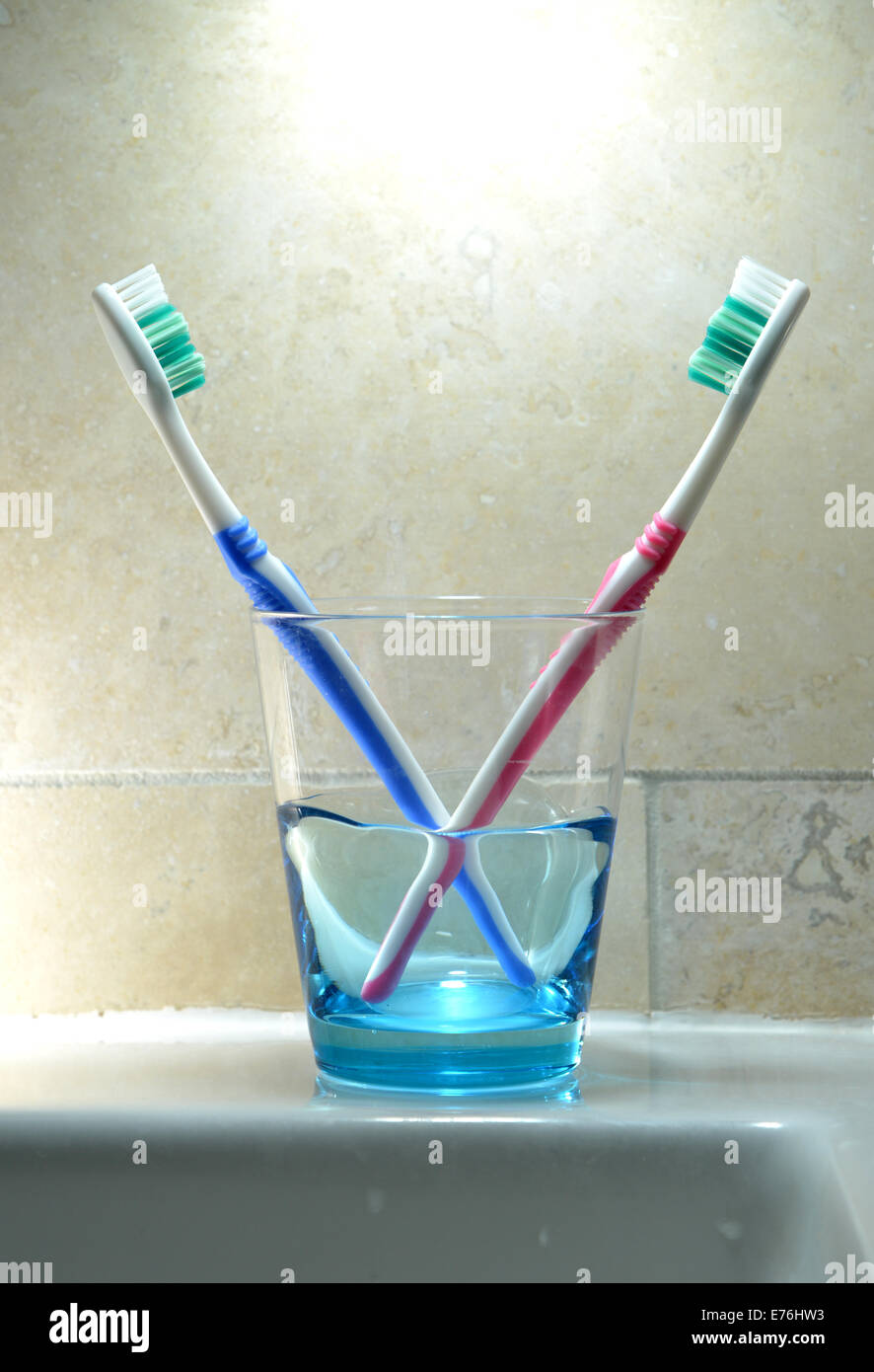 Pink and blue toothbrushes facing each other Stock Photo - Alamy