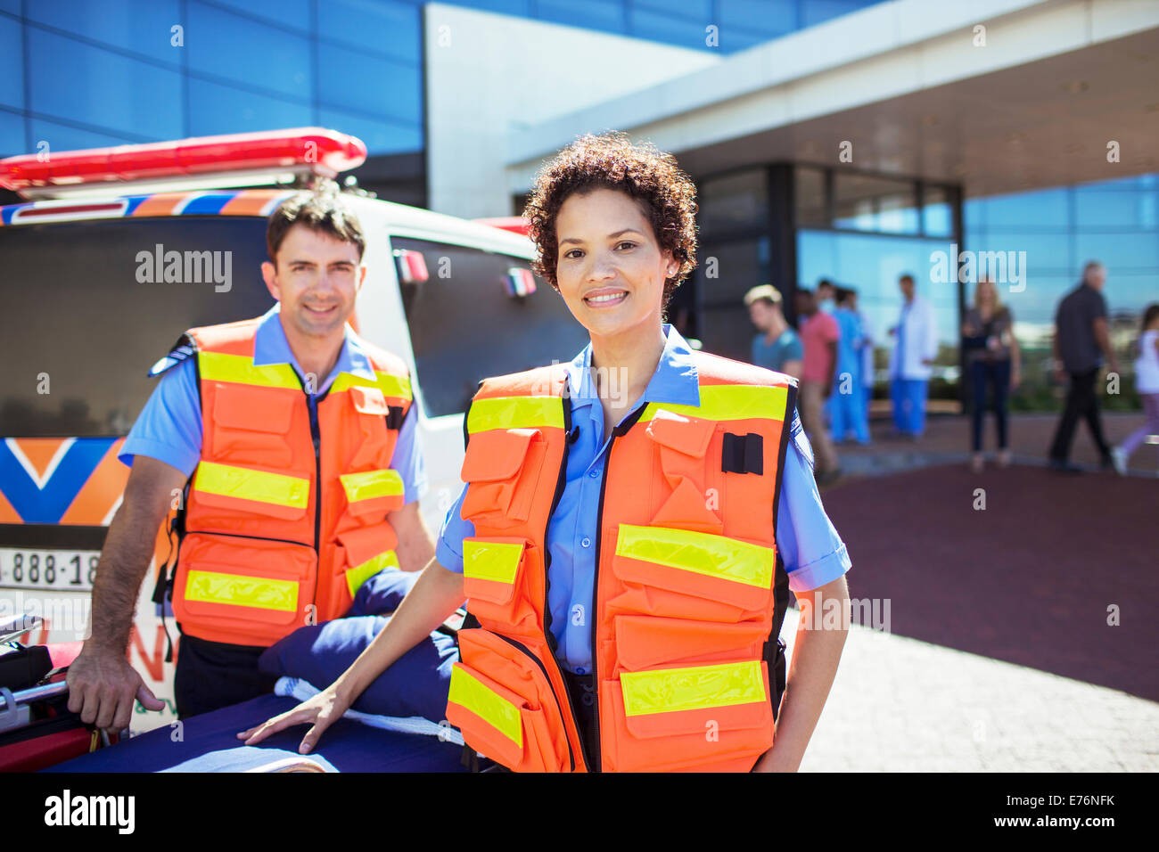Paramedics smiling by ambulance in hospital parking lot Stock Photo - Alamy