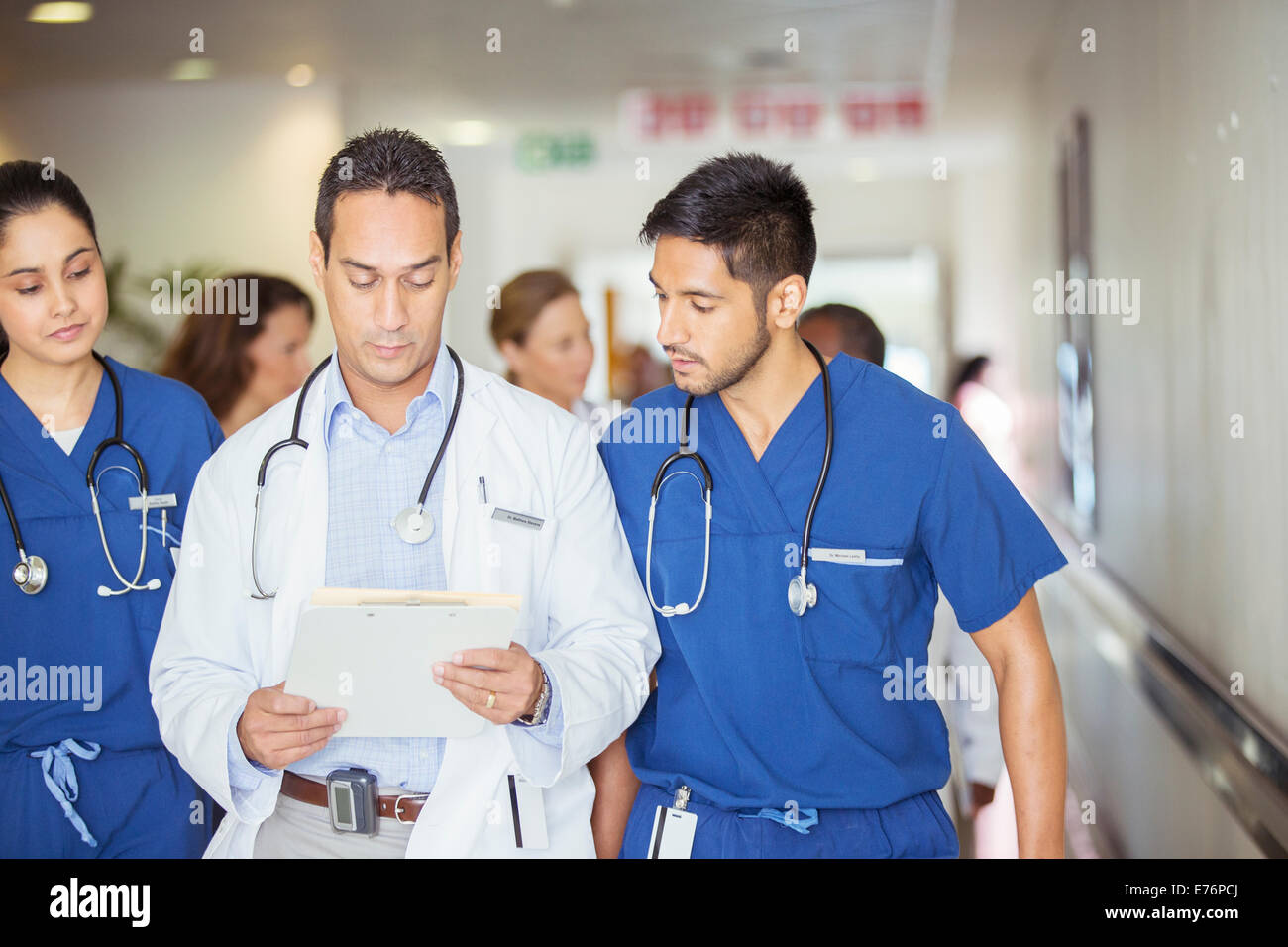 Doctor and nurses reading medical chart in hospital hallway Stock Photo ...