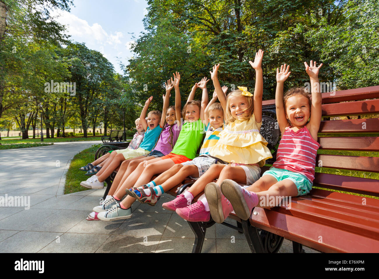 Group of kids on the bench cheering lifting hands Stock Photo - Alamy