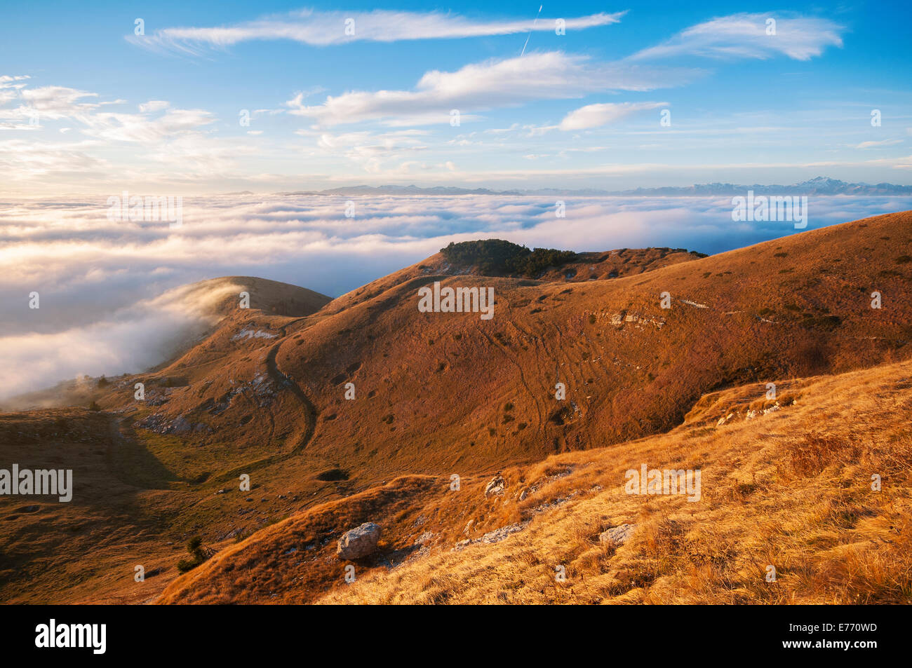 On top of the mountain,sunset light emerges from clouds Stock Photo - Alamy