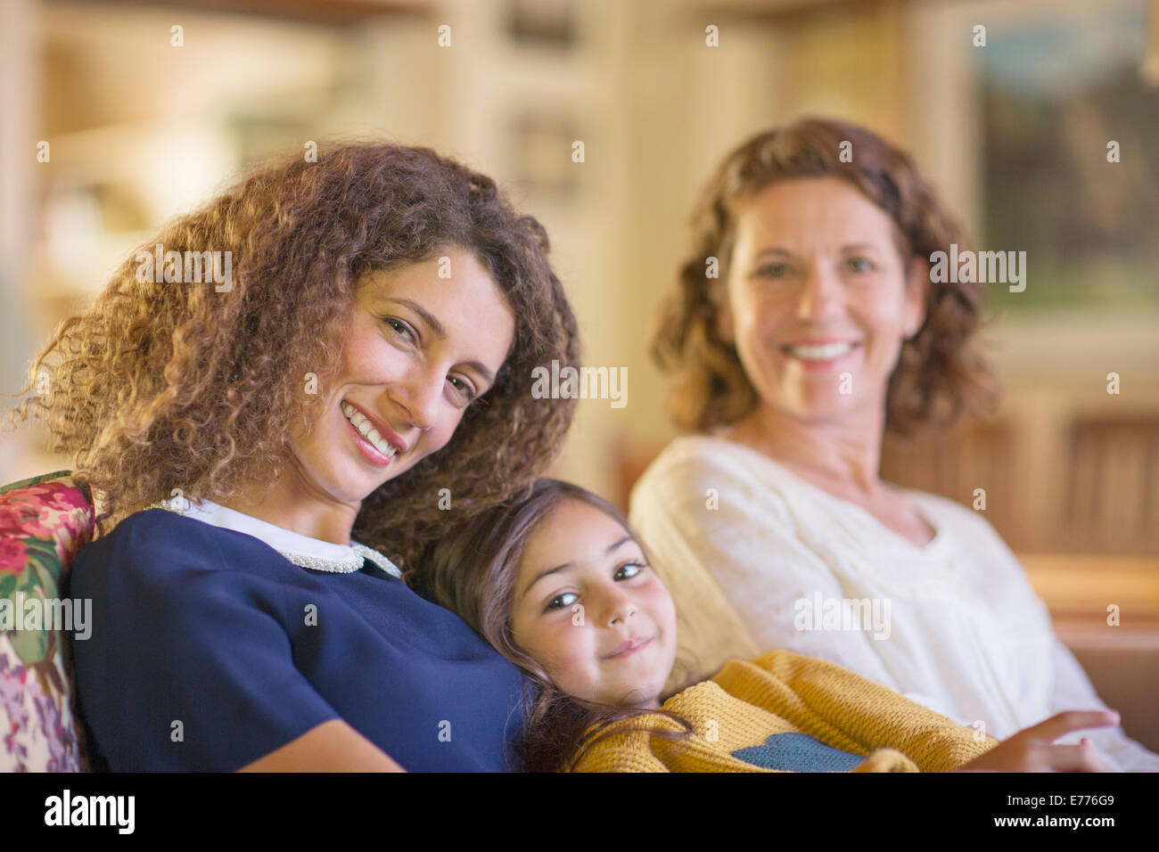 Three generations of women relaxing on couch together Stock Photo - Alamy