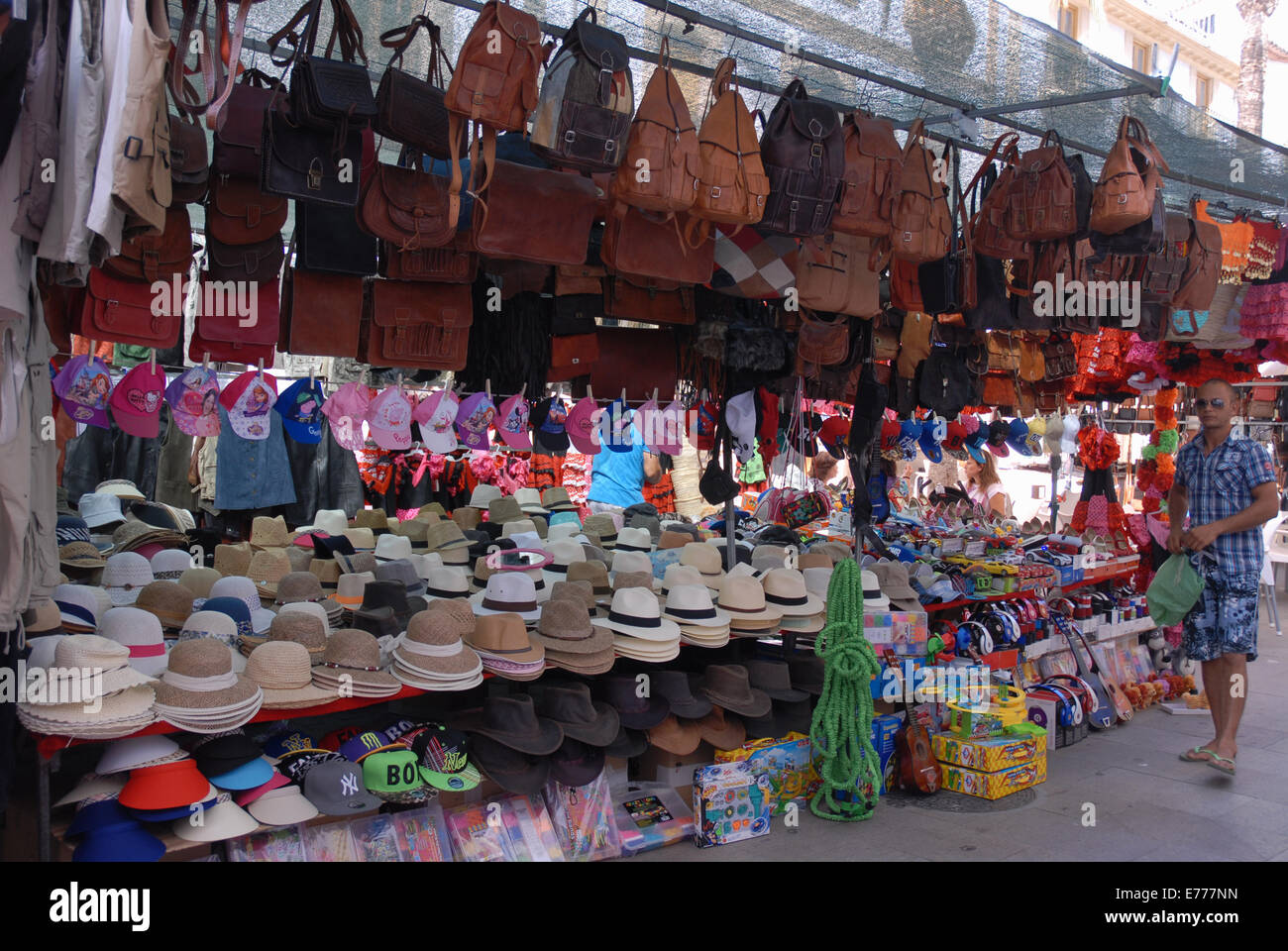 Street market stall with hats, leather bags and toys at the Thursday ...