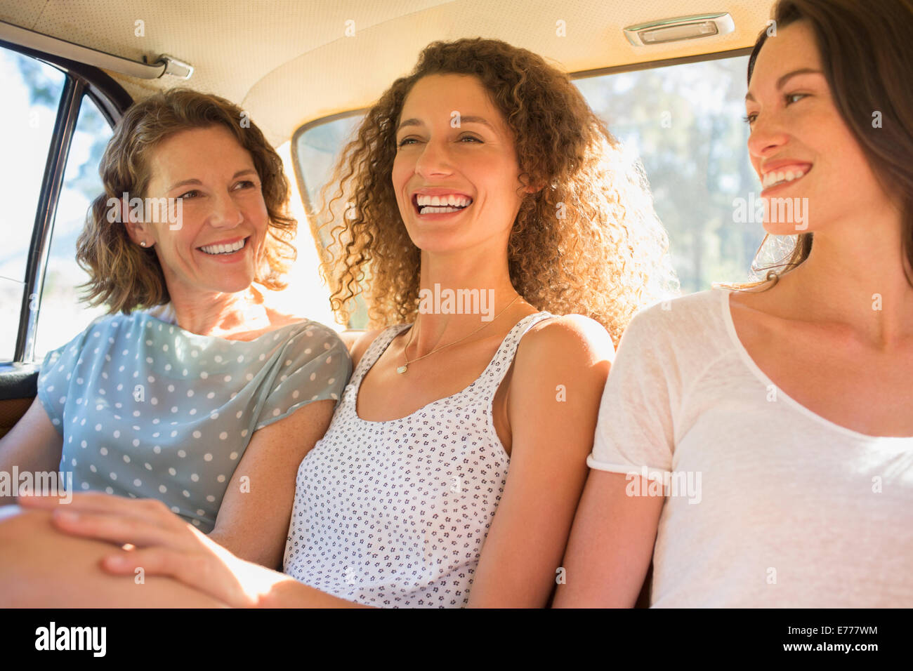 Three women sitting in car backseat together Stock Photo - Alamy