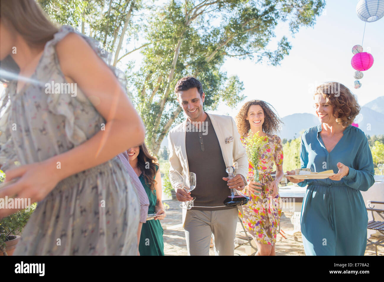 Family moving dishes from table outdoors Stock Photo - Alamy