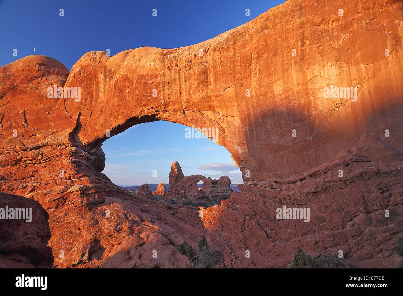 Turret Arch seen through the North Window Arch at sunrise in Arches ...