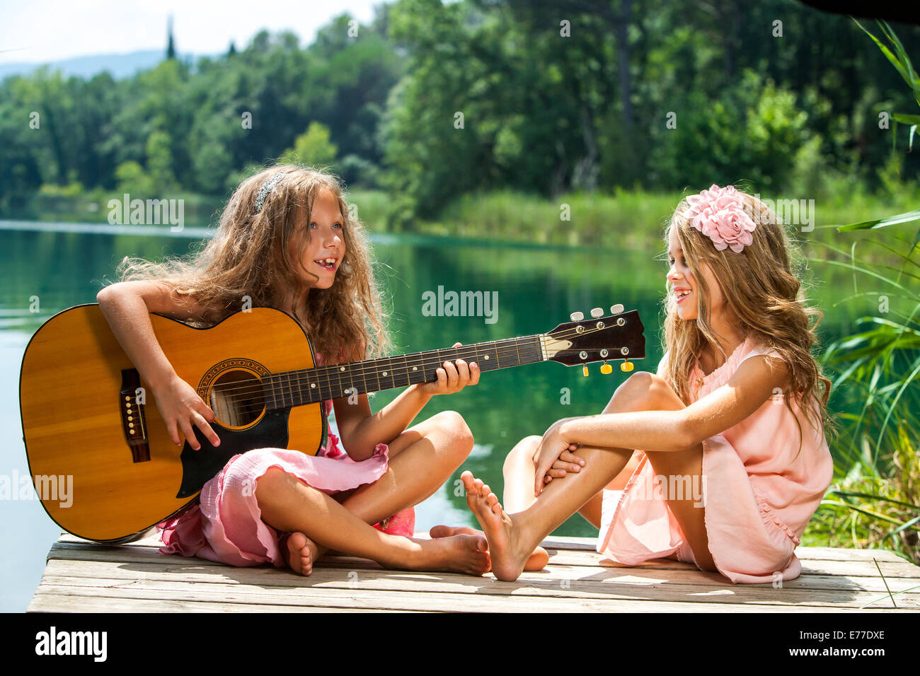 Portrait of two young girls singing together at lakeside Stock Photo ...