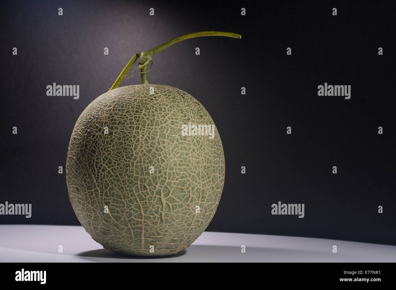rock melon on a black background with a single light Stock Photo - Alamy