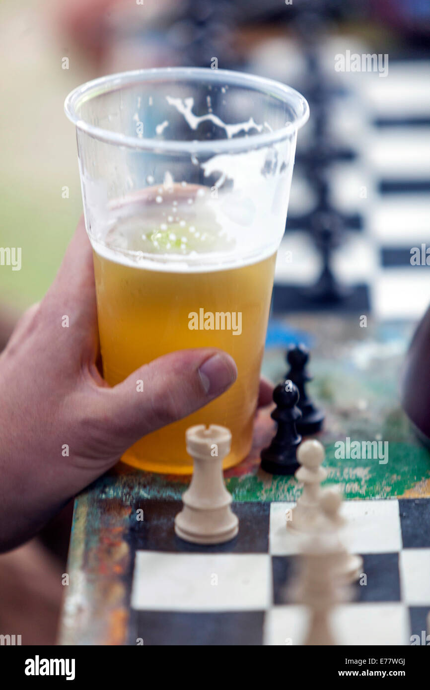 Chess pieces and hand with a beer in a plastic cup, Czech daily life ...