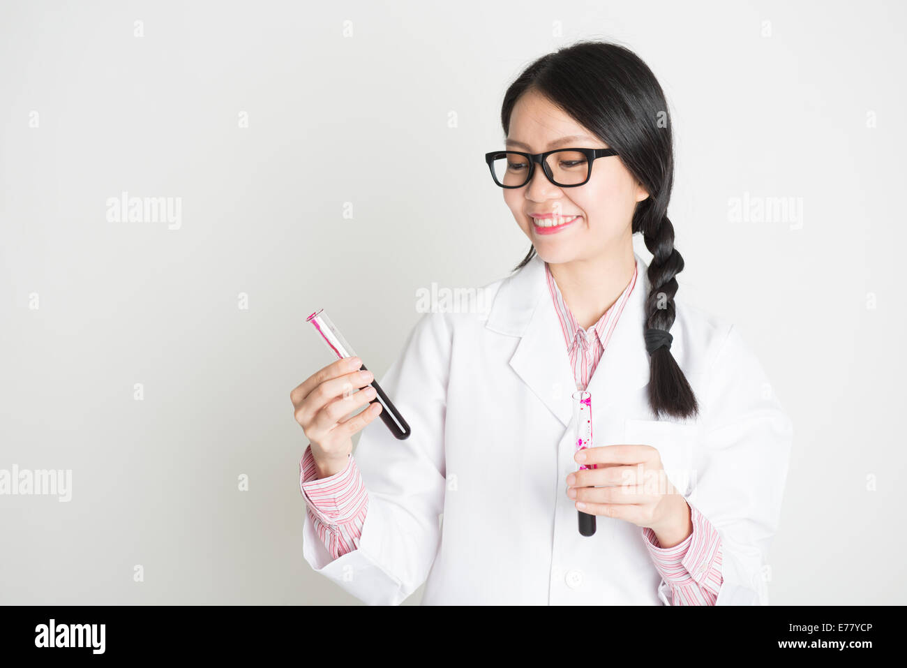 Asian female lab worker doing blood sample test analysis, on plain ...