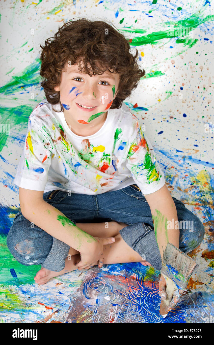 Adorable boy playing with the background painted Stock Photo - Alamy