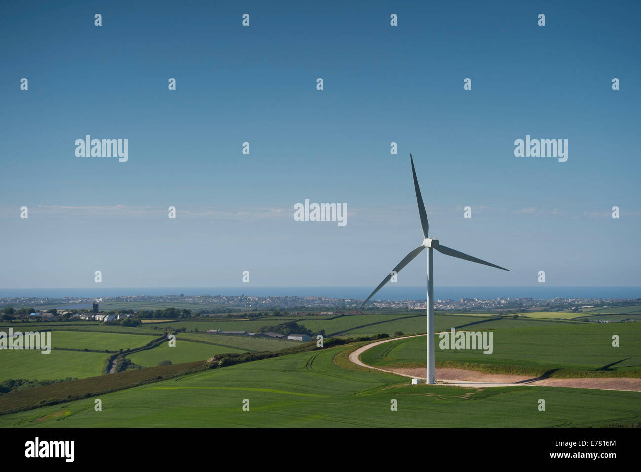 Wind turbines producing green renewable energy on green hills in near ...