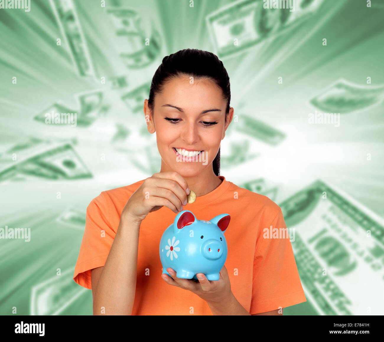 Pretty brunette woman inserting a coin in a piggy-bank isolated on ...