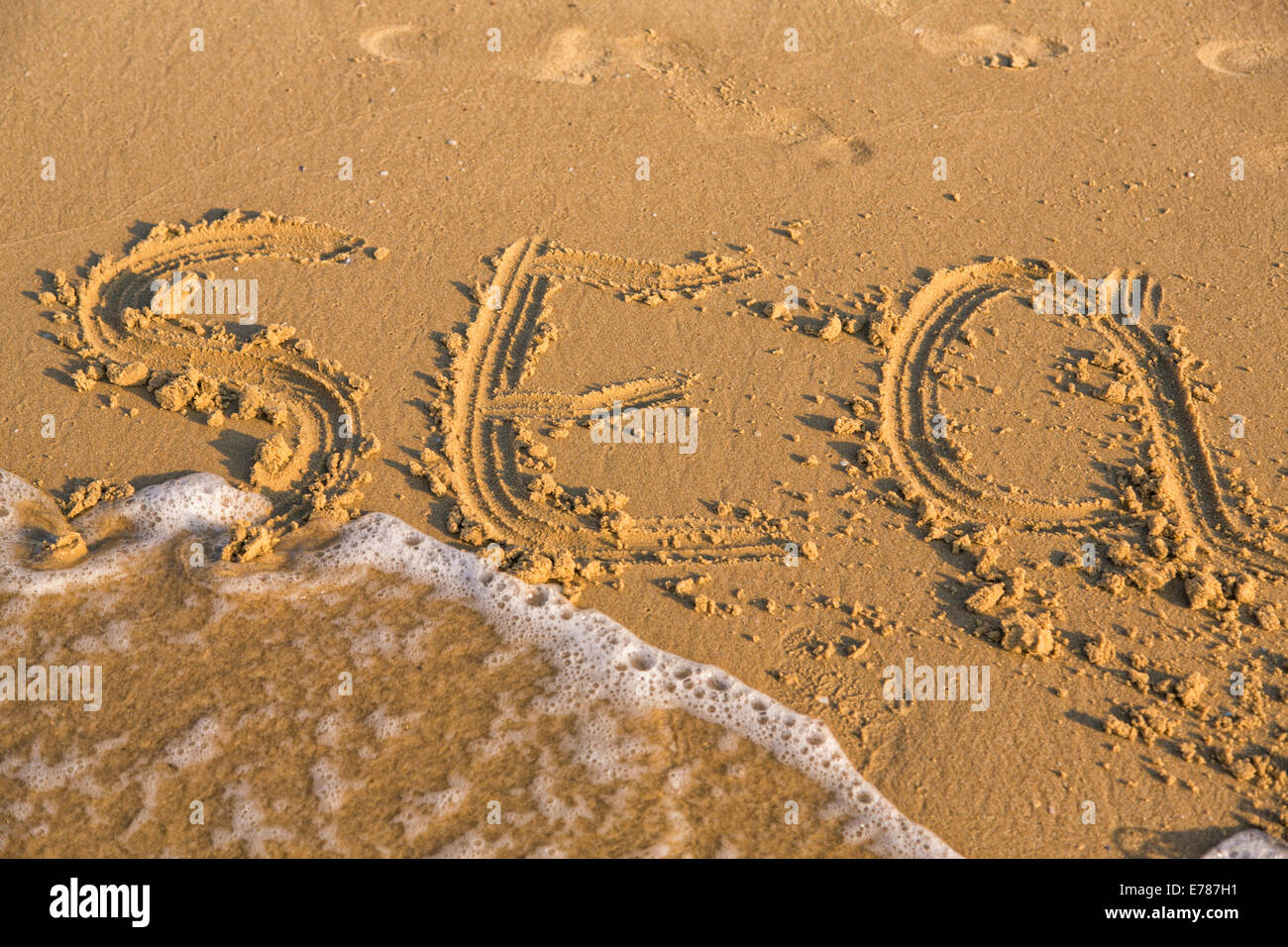 Word sea on the yellow sandy beach, text Stock Photo - Alamy