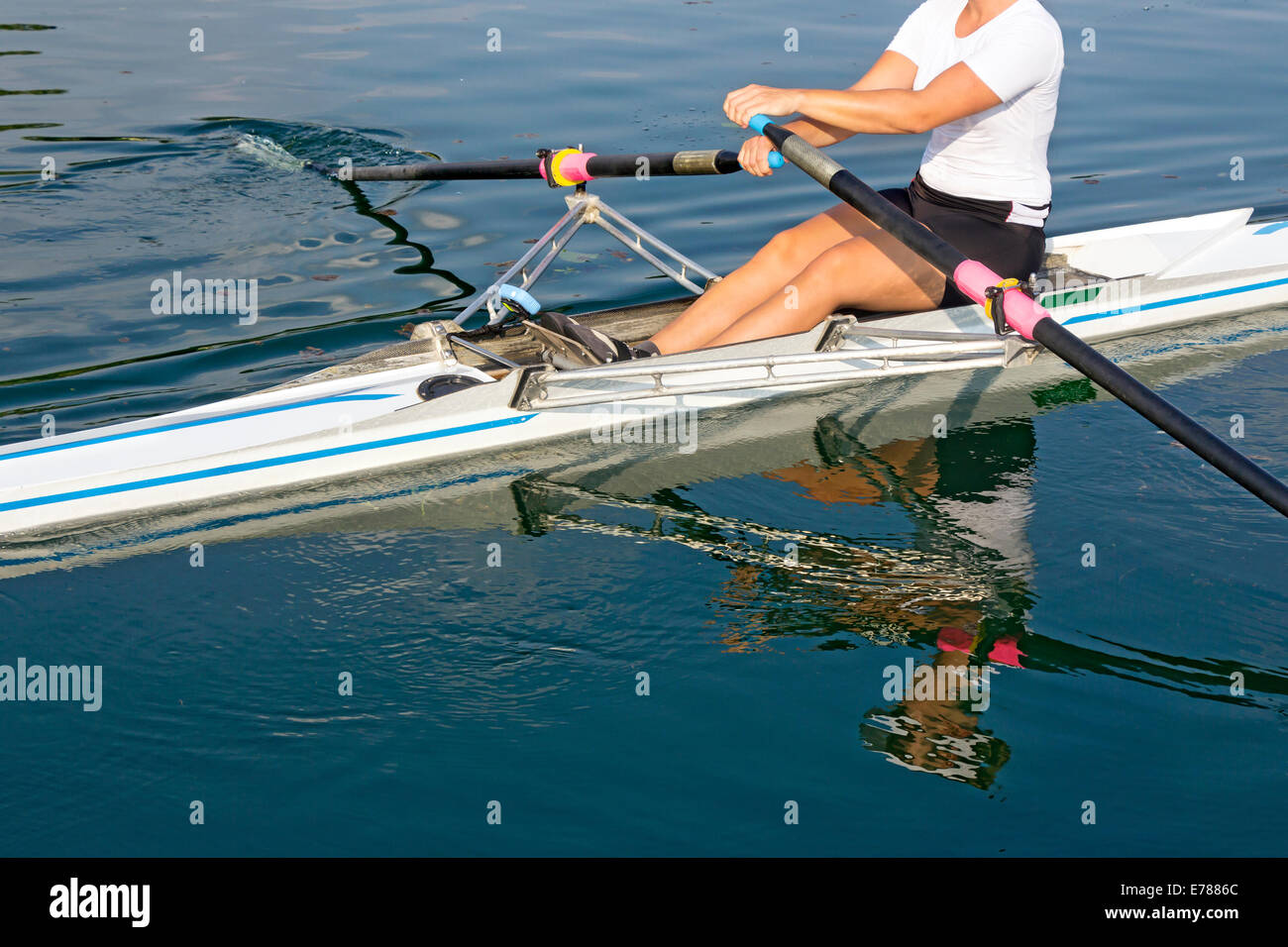 A young rower in a boat, paddles on the tranquil lake Stock Photo - Alamy