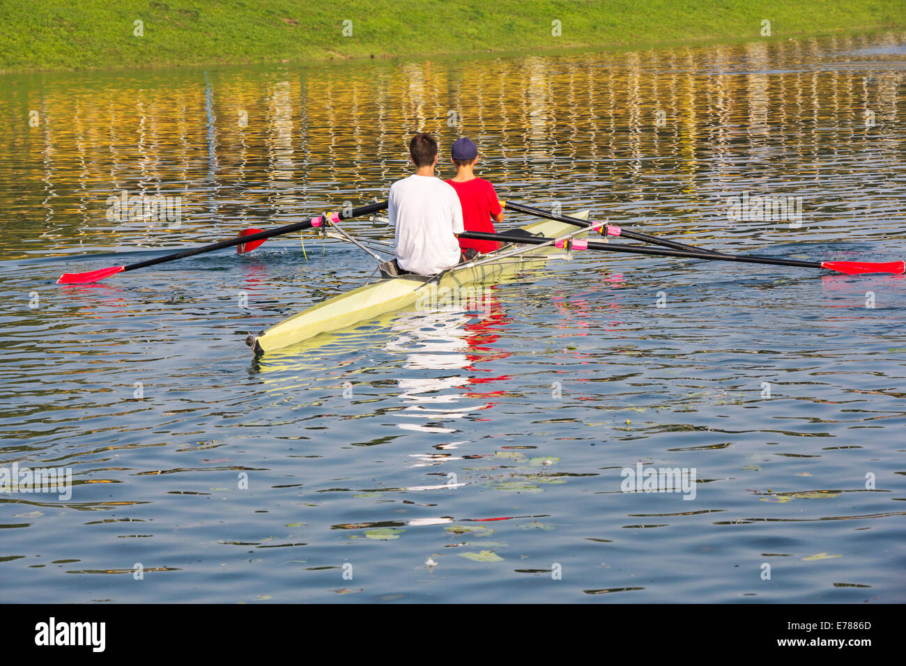 Two rowers in a boat, paddles on the tranquil lake Stock Photo - Alamy