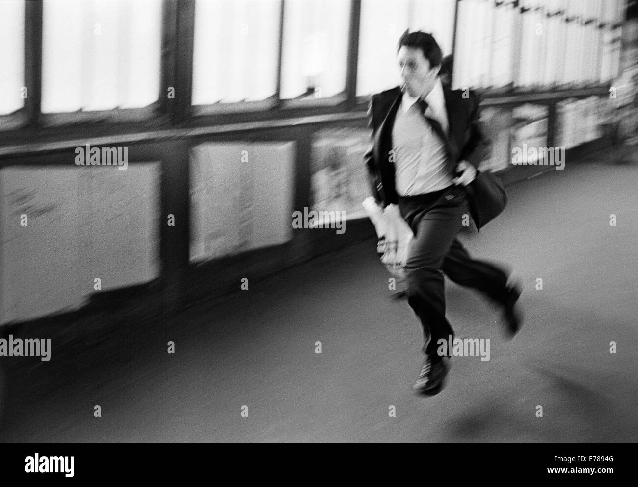 Commuter, late for train, rushing across footbridge in Waterloo ...