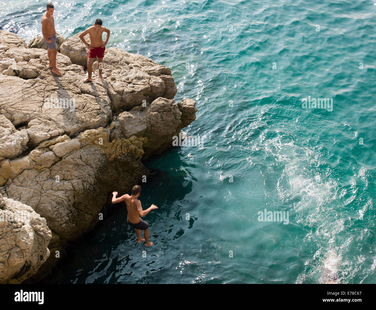 Boys diving off cliffs into the blue sea in Nice, France Stock Photo ...