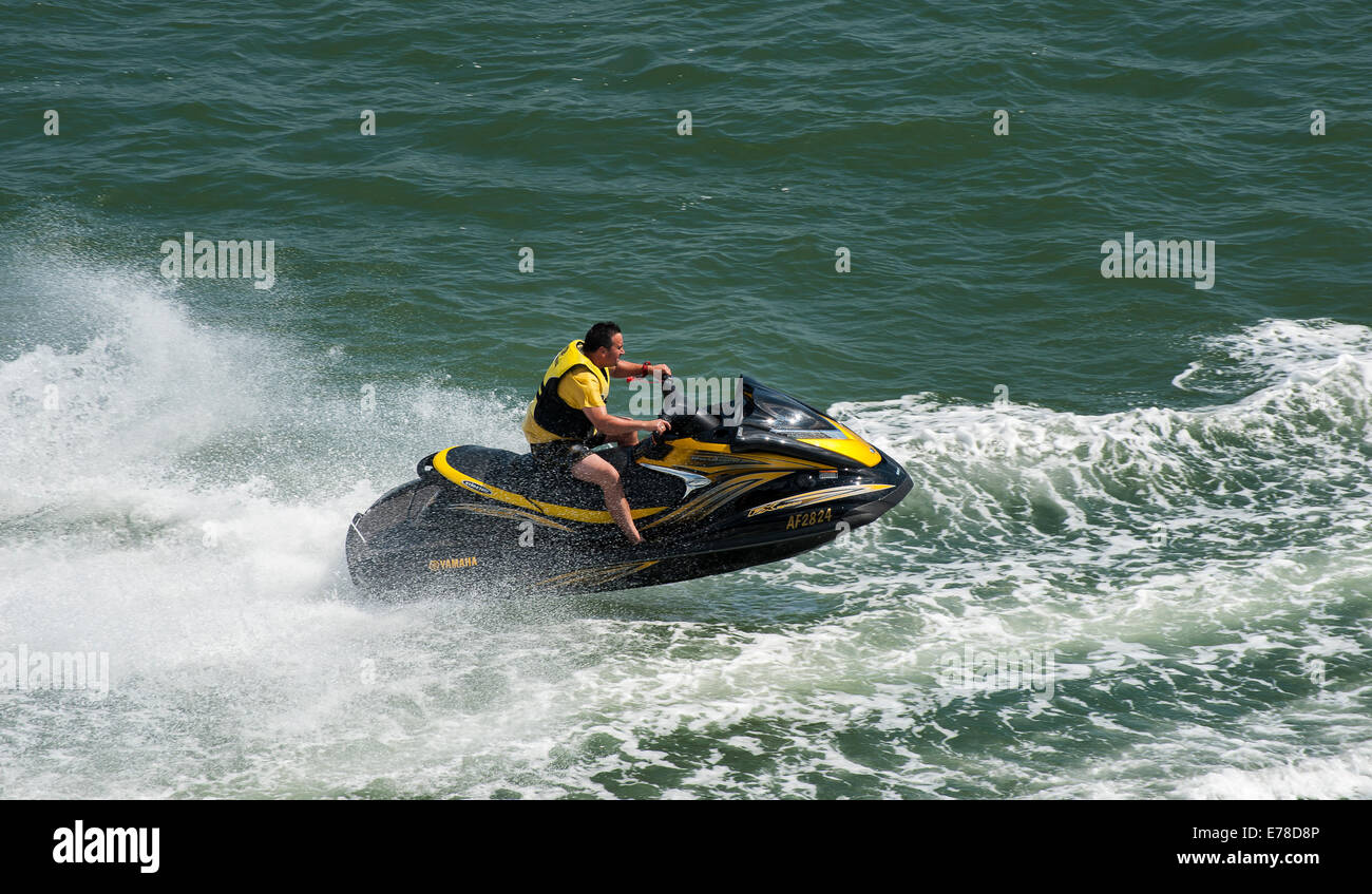 Man racing along in the water on a jetski Stock Photo - Alamy