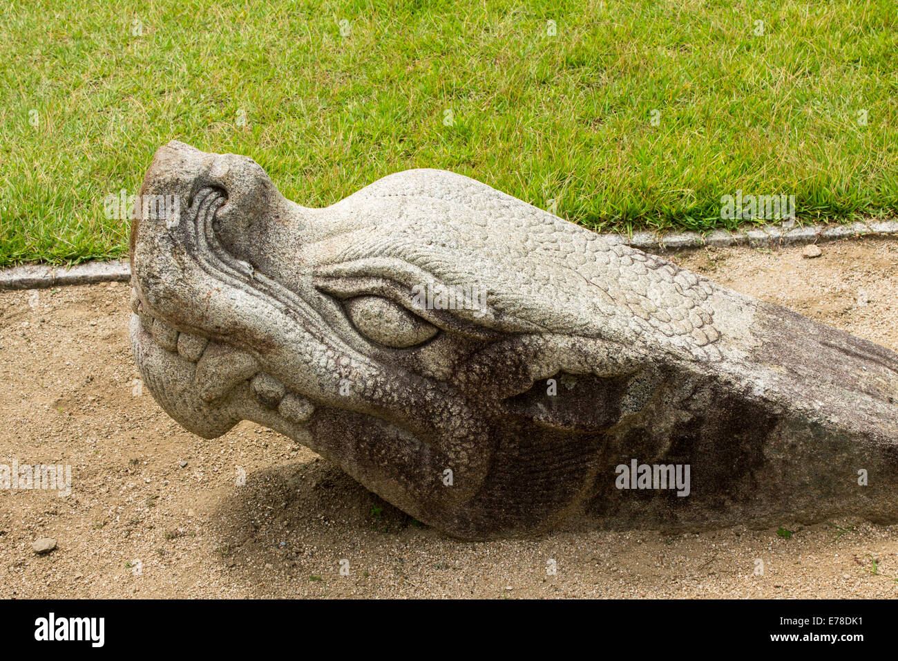 stone head of a monster sticking out of the ground Stock Photo - Alamy