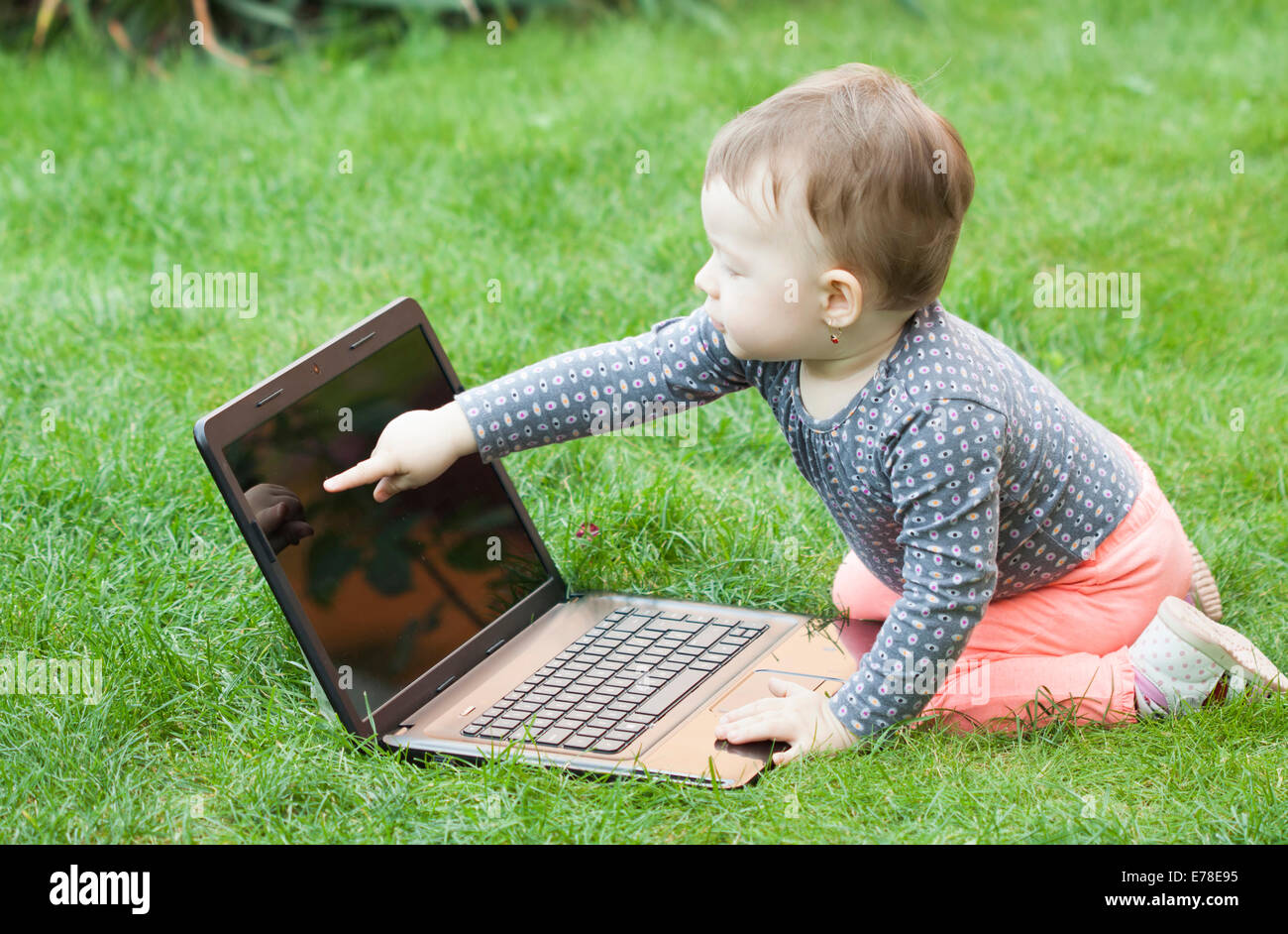 Curious baby with laptop computer laying in the grass Stock Photo - Alamy