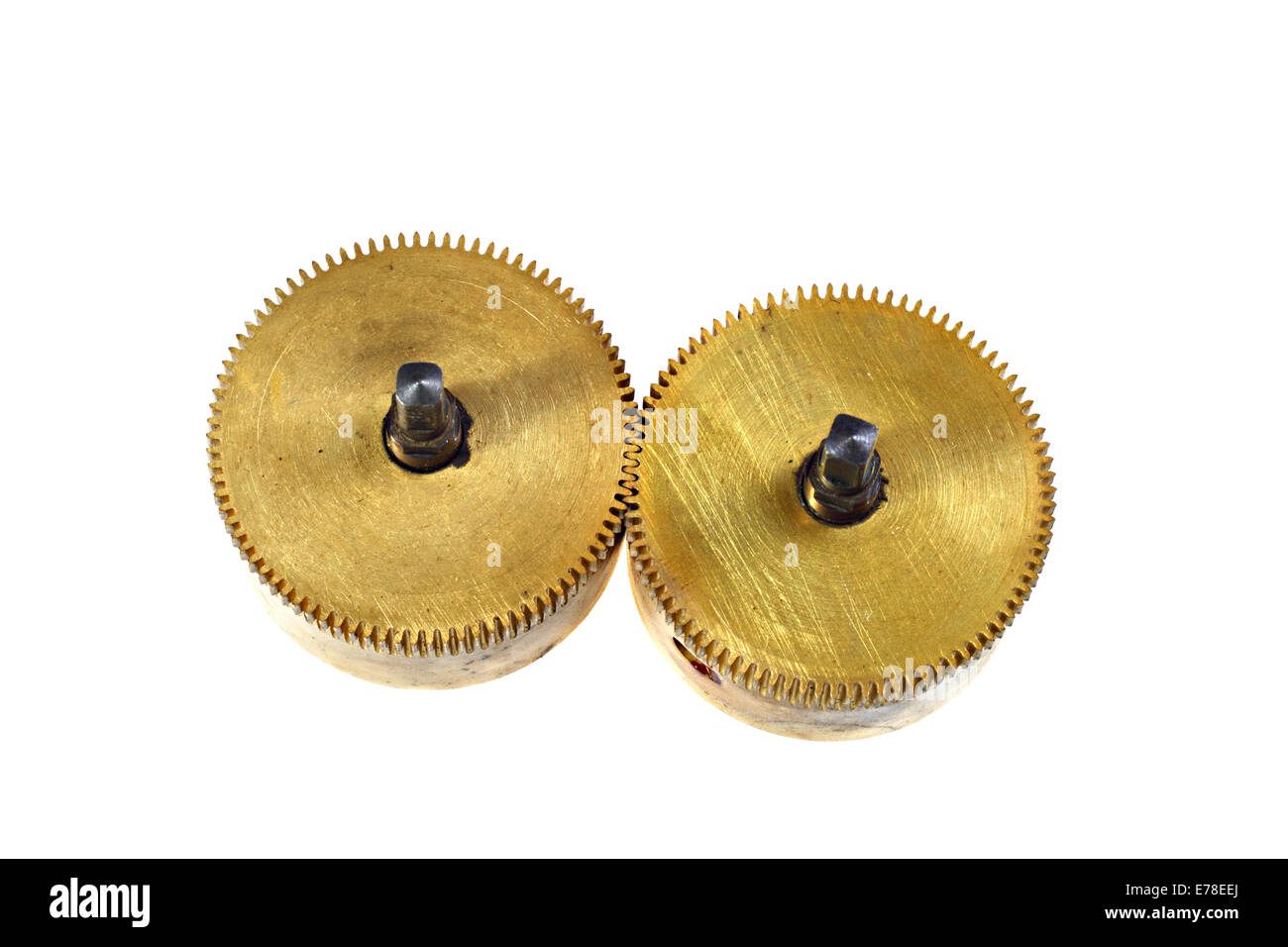 Two massive brass pinions in interlocking isolated on white background ...