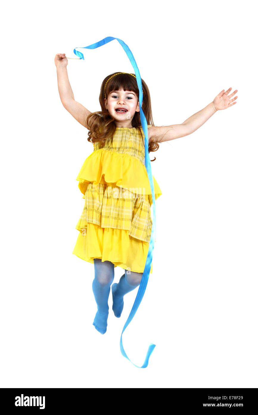 Little girl in yellow dress jumps with blue ribbon in hand. Isolated on ...