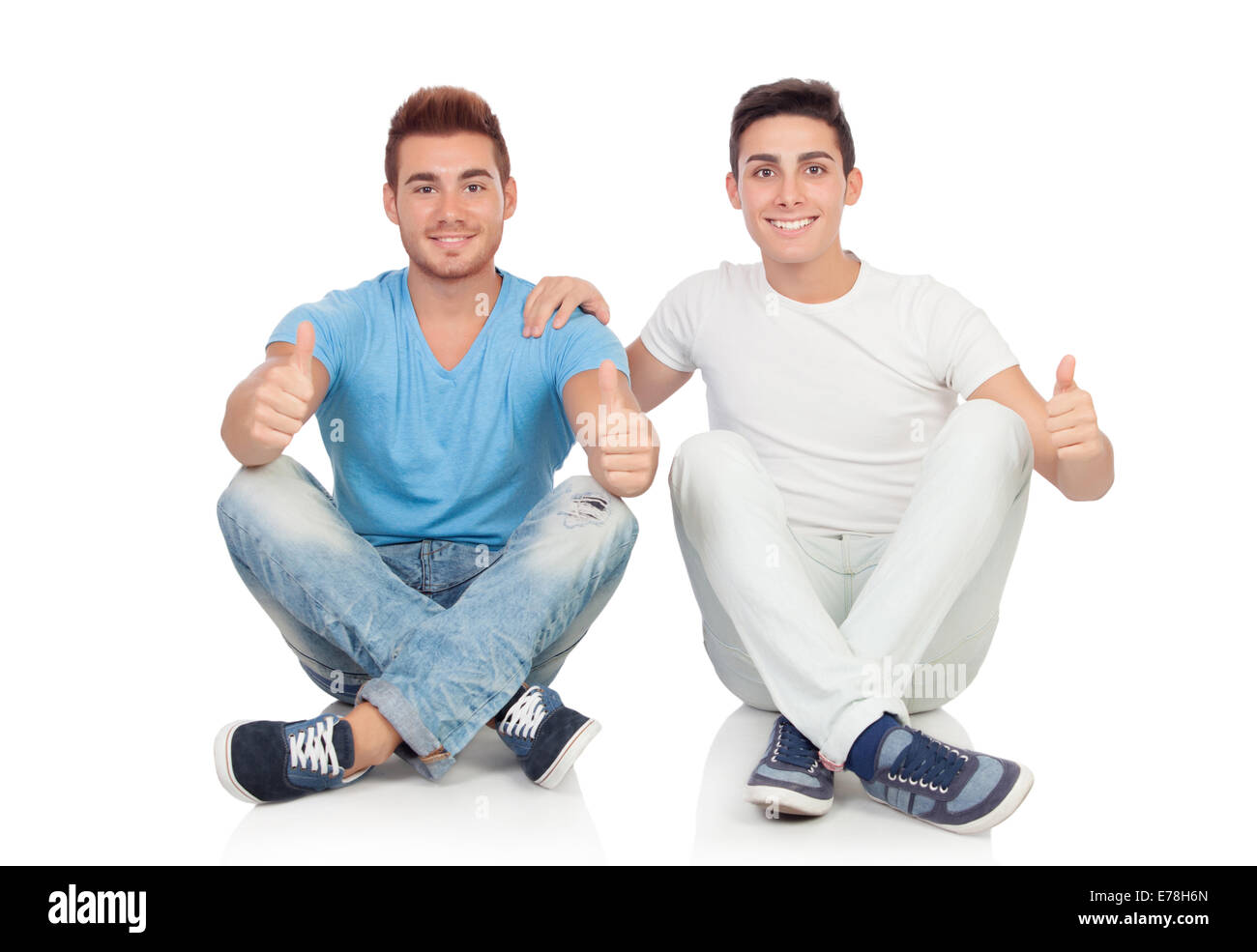 Portrait of two brothers sitting saying Ok isolated on a white ...