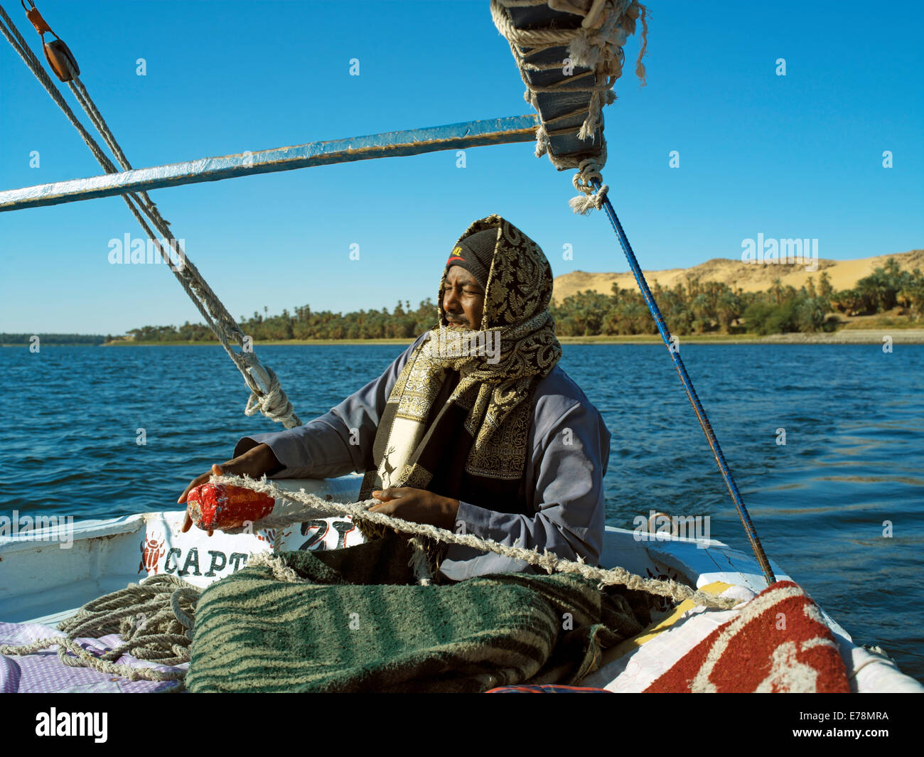A felucca boat captain singing whilst at the helm sailing the Nile ...