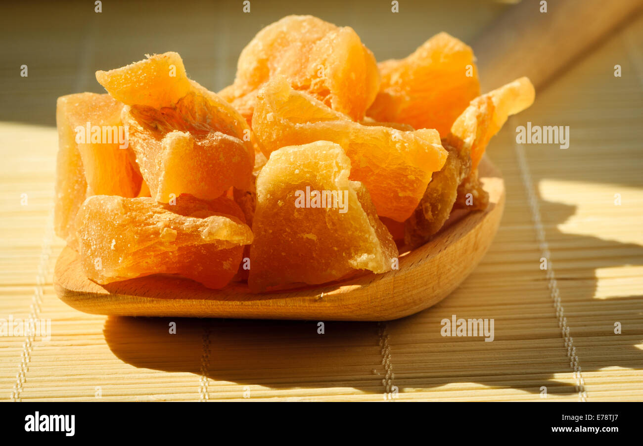 Closeup candied crystallized ginger candy pieces on wooden spoon ...