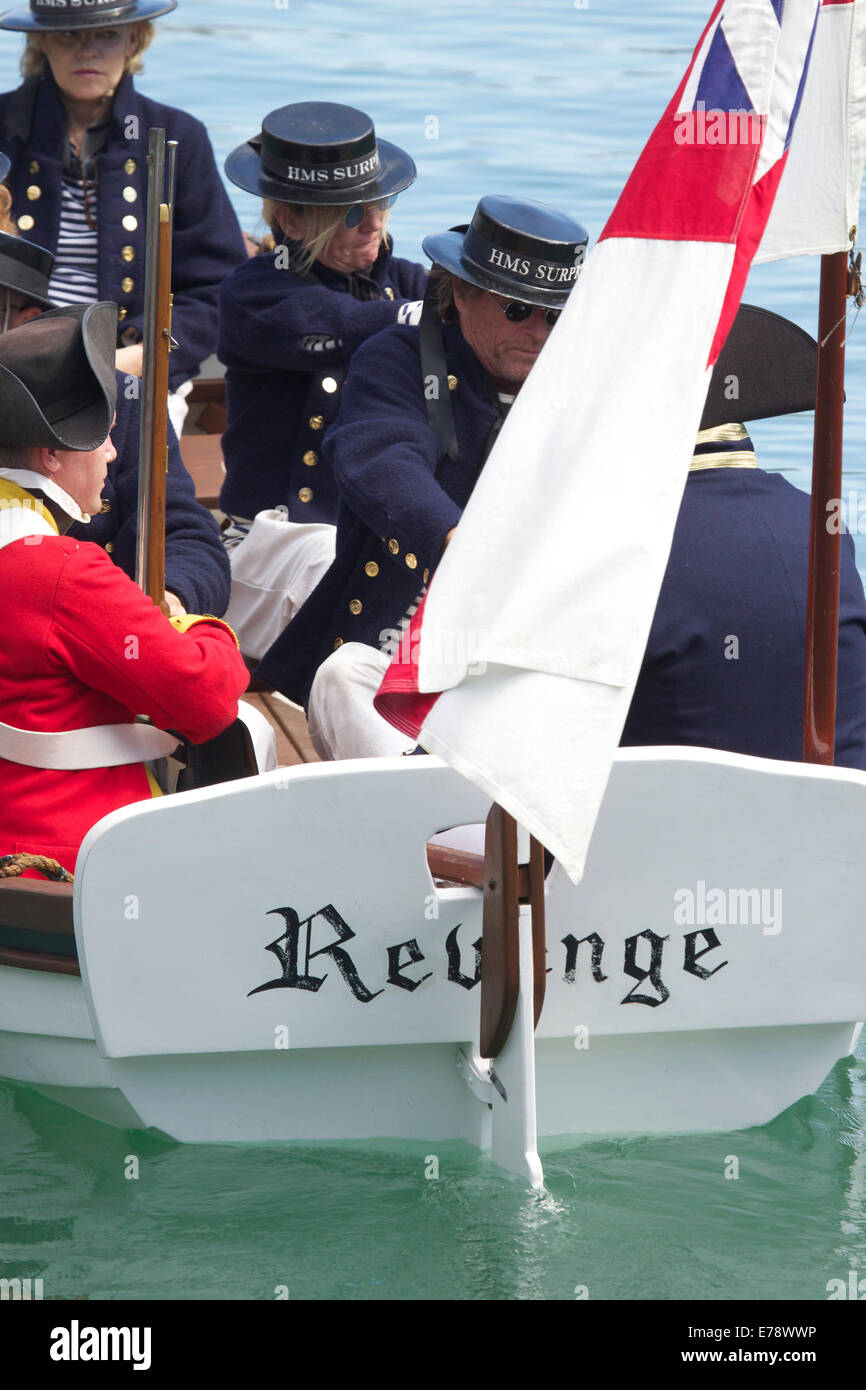 Performers dressed as British sailors in a long boat entertain crowds ...