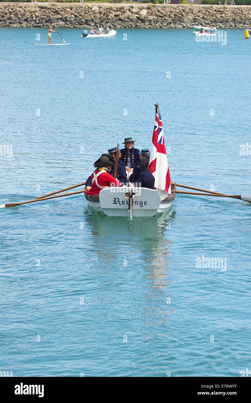 Performers dressed as British sailors in a long boat entertain crowds ...