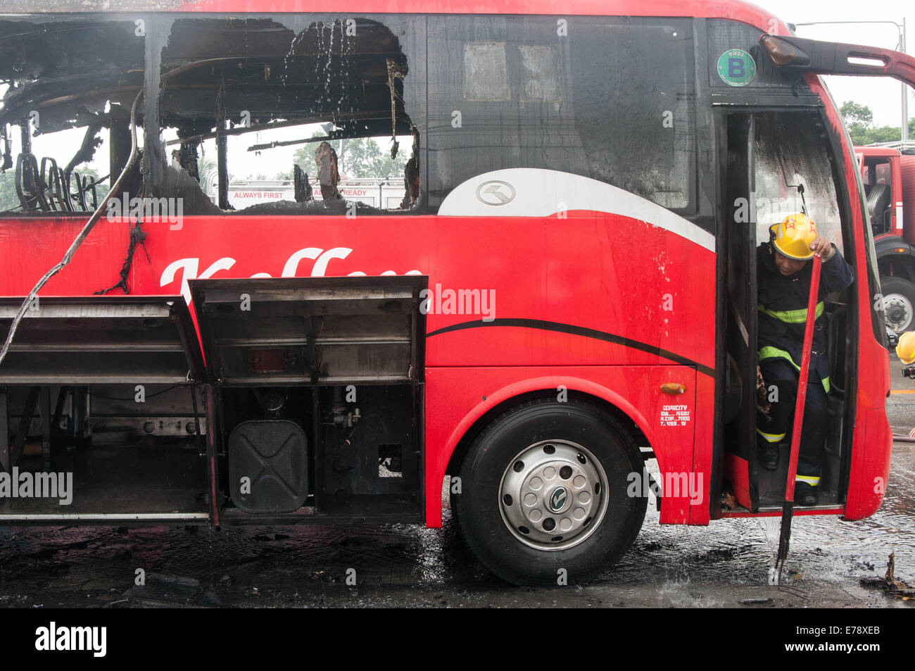 A firefighter steps out of the burned passenger bus along the ...