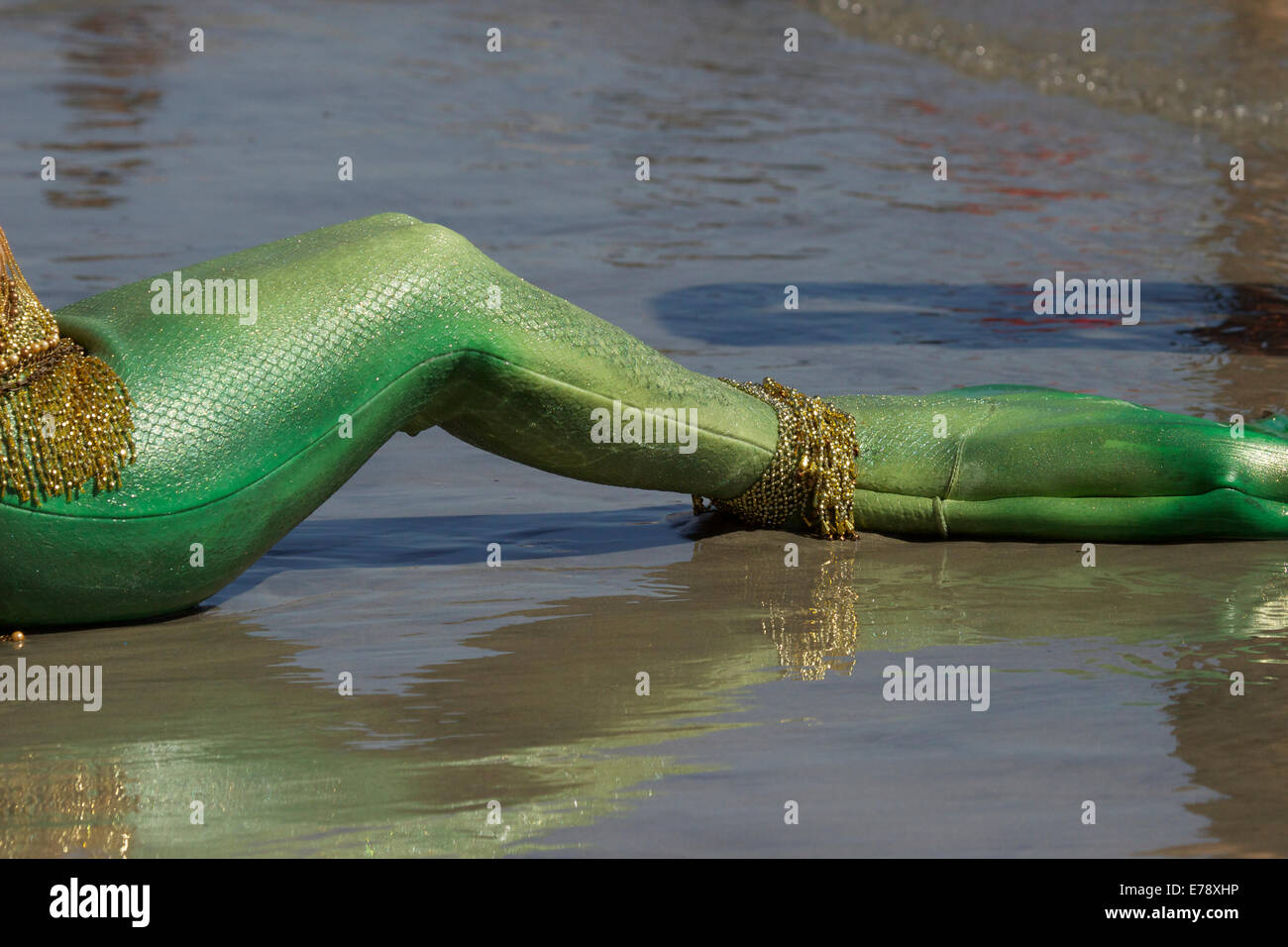 Mermaids tail at the edge of the water reflected by the wet sand Stock ...