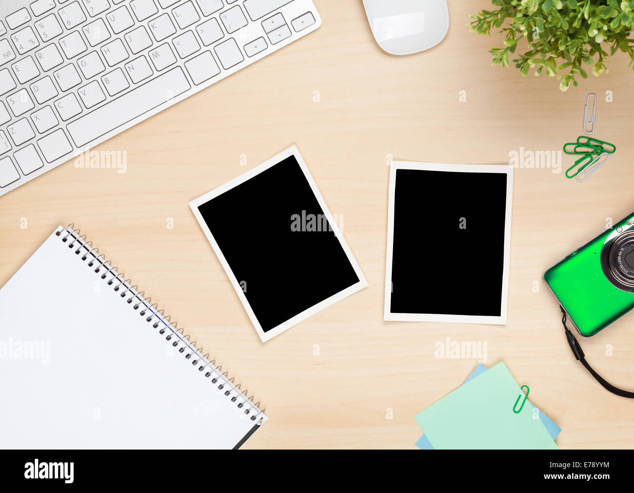 Photo frames on office table with notepad, computer and camera. View ...