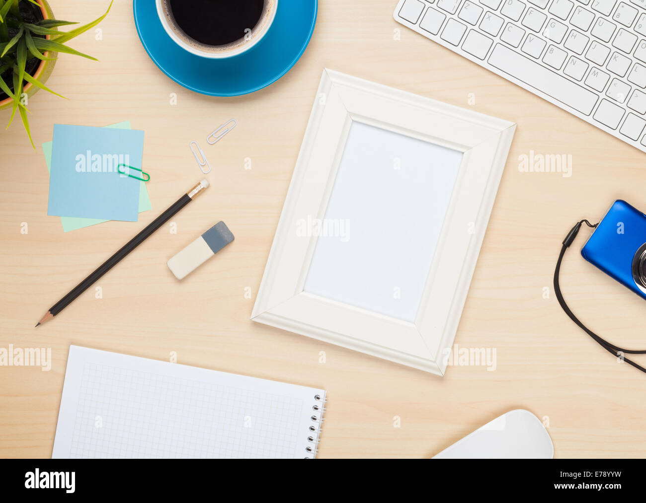 Photo frame on office table with notepad, computer and camera. View ...