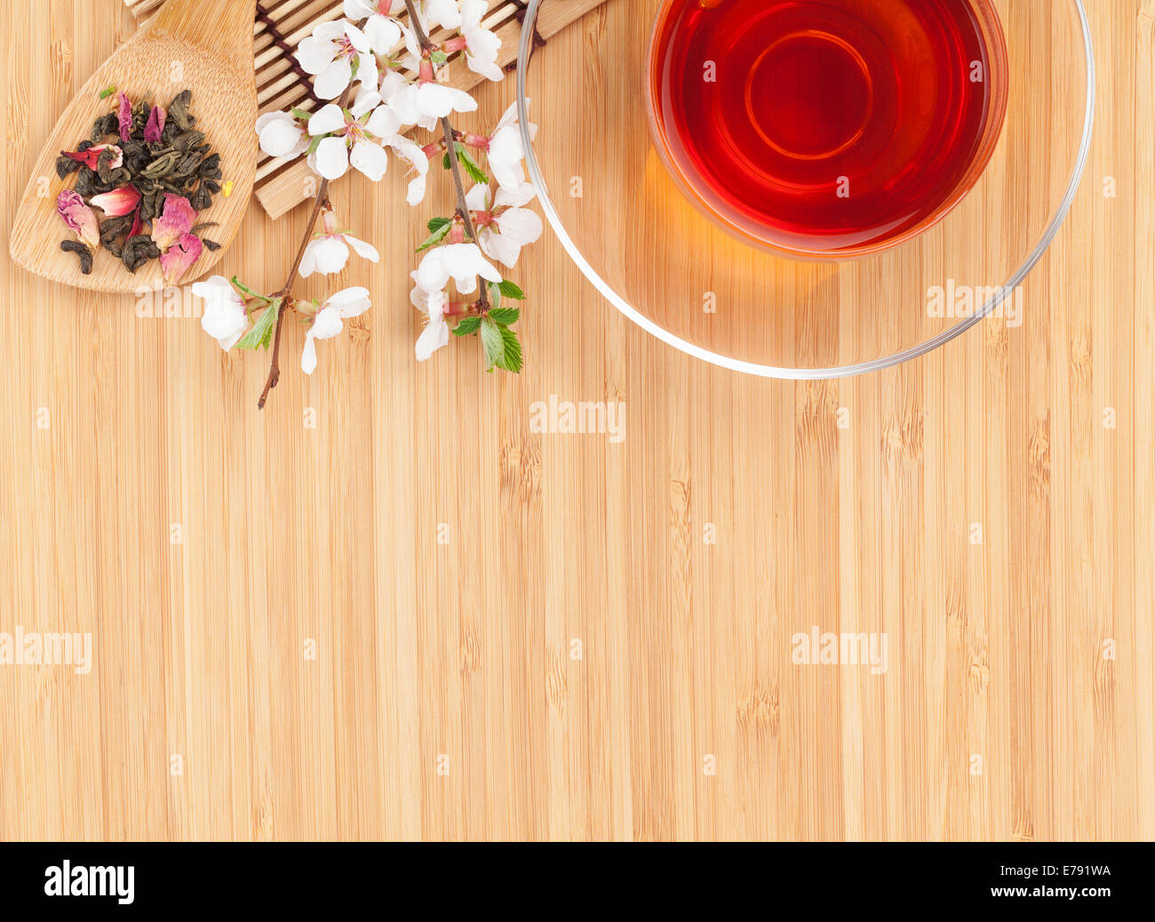 Japanese green tea and sakura branch over bamboo table with copy space ...