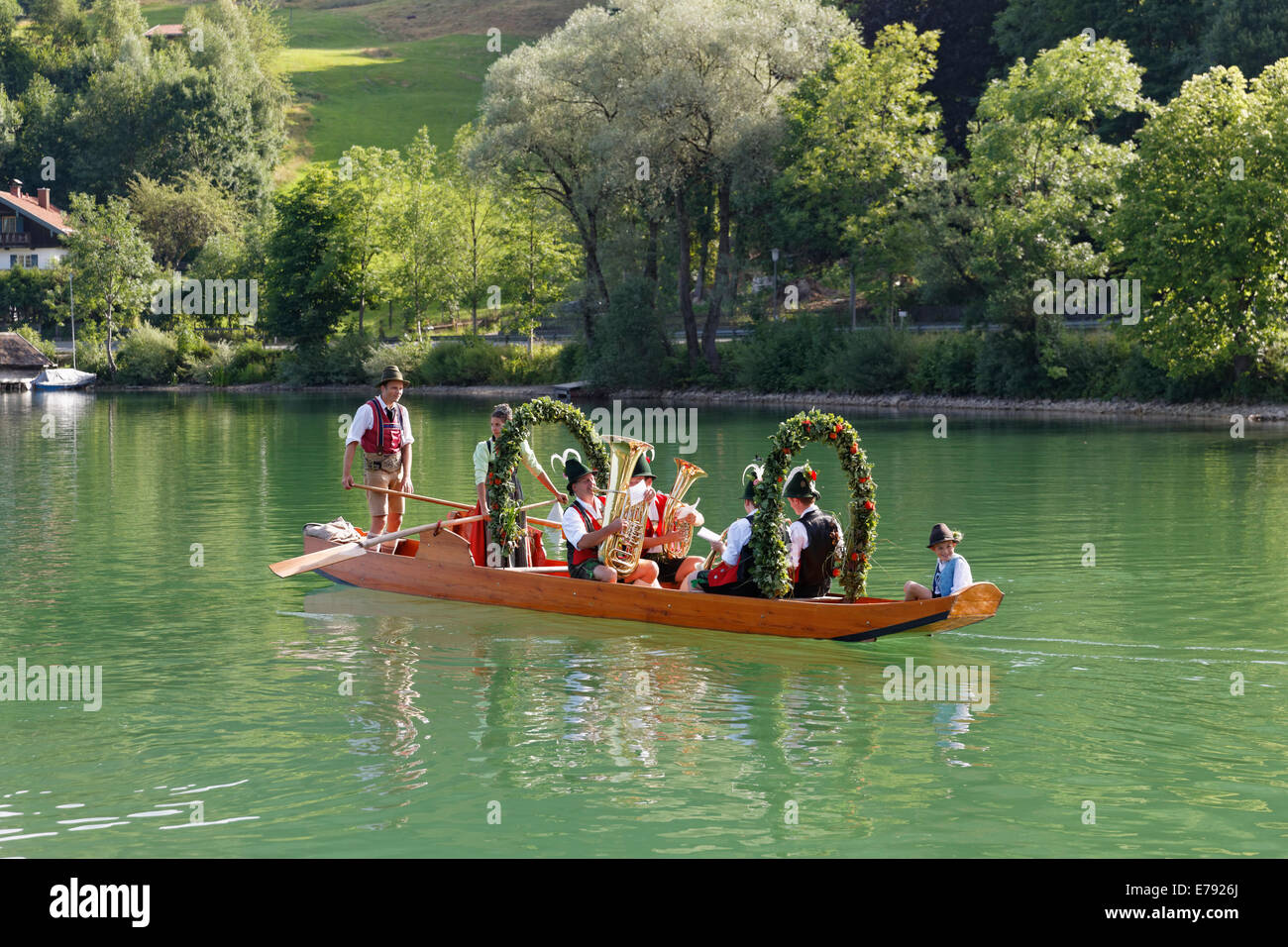 Locals wearing traditional costumes in a decorated wooden Plätte boat ...