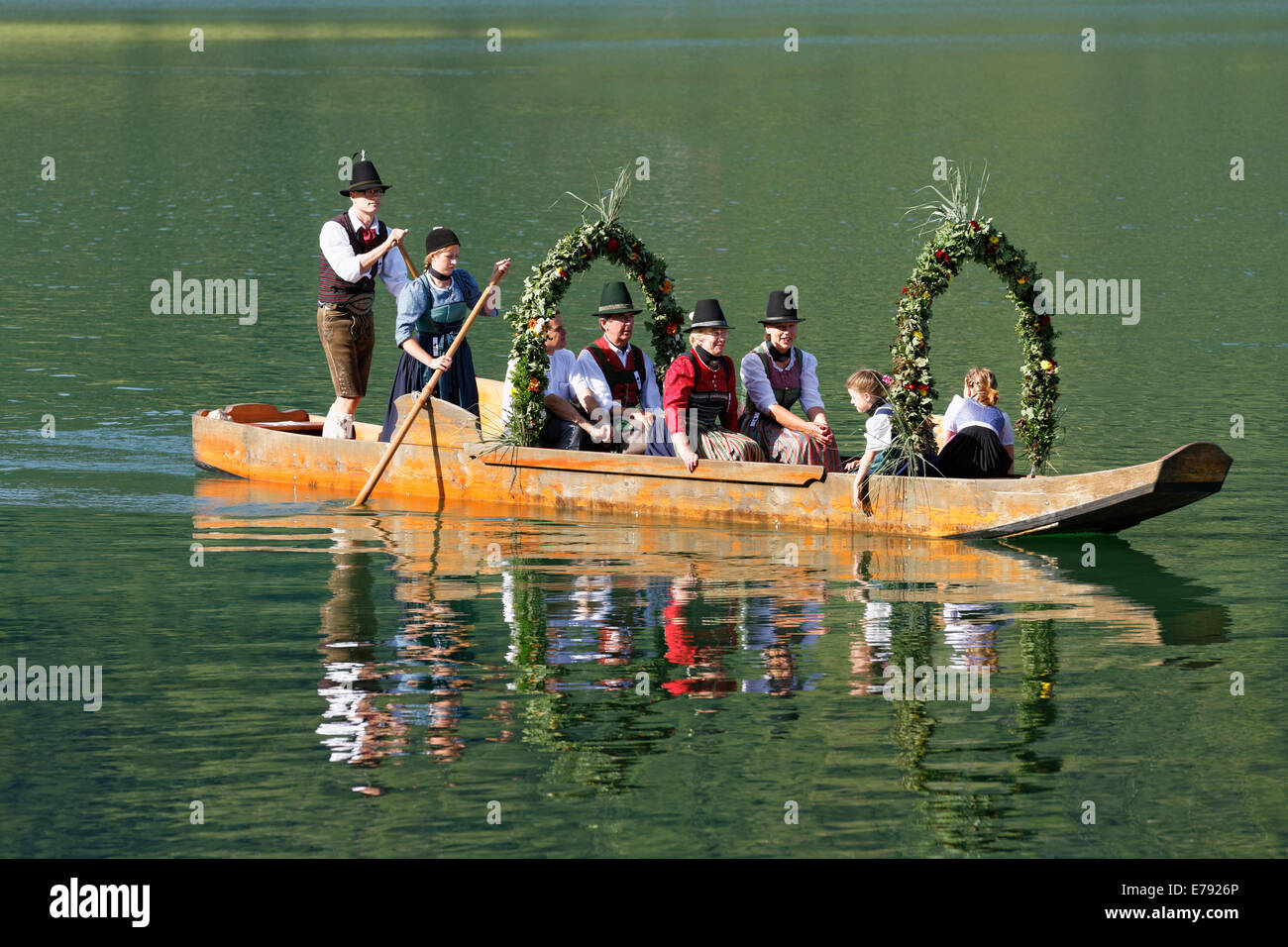 Locals wearing traditional costumes in a decorated wooden Plätte boat ...