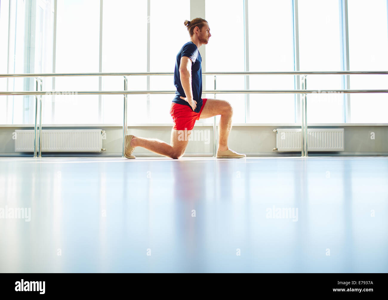 Handsome young man practicing physical exercise in gym Stock Photo - Alamy
