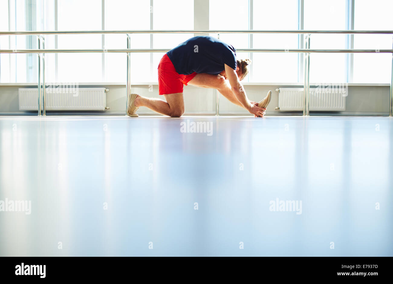 Handsome guy in sportswear practicing physical exercise in gym Stock ...