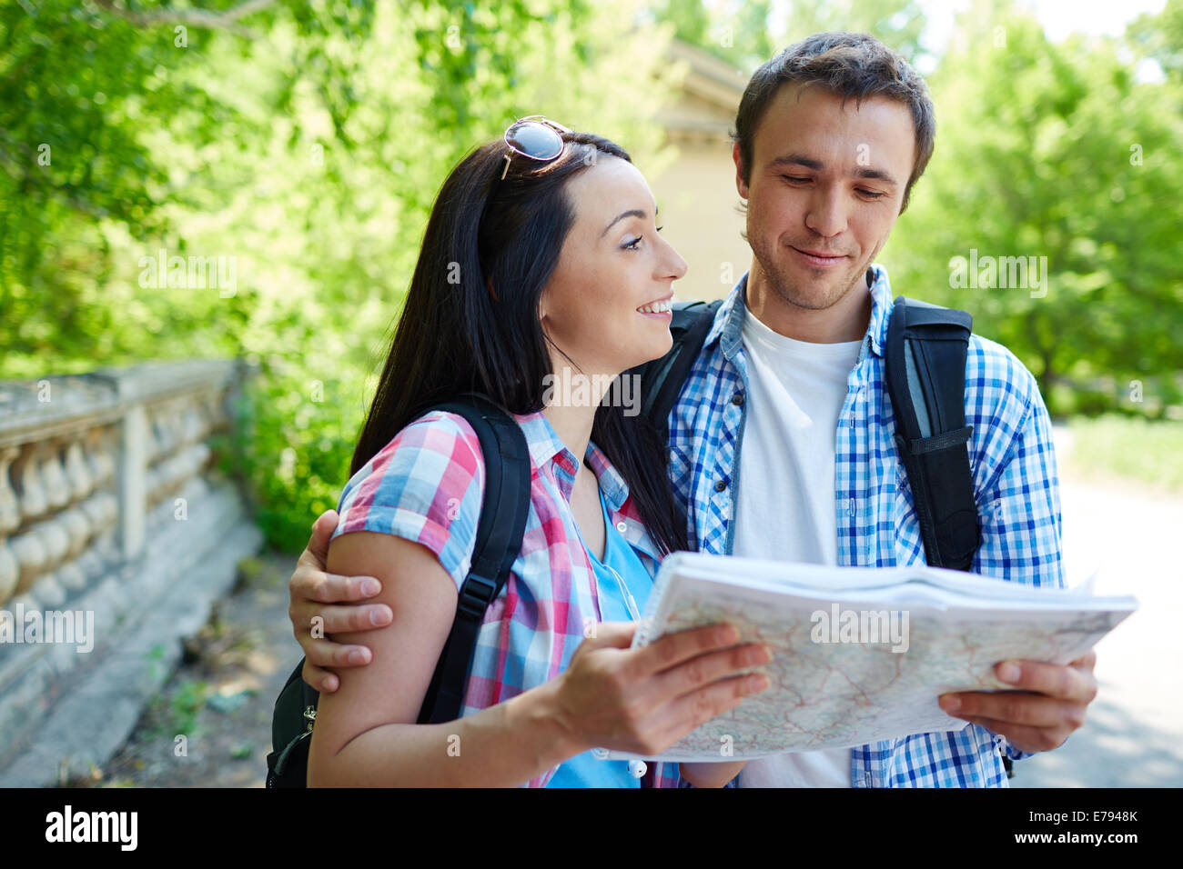 Modern travelers with map discussing where to go Stock Photo - Alamy