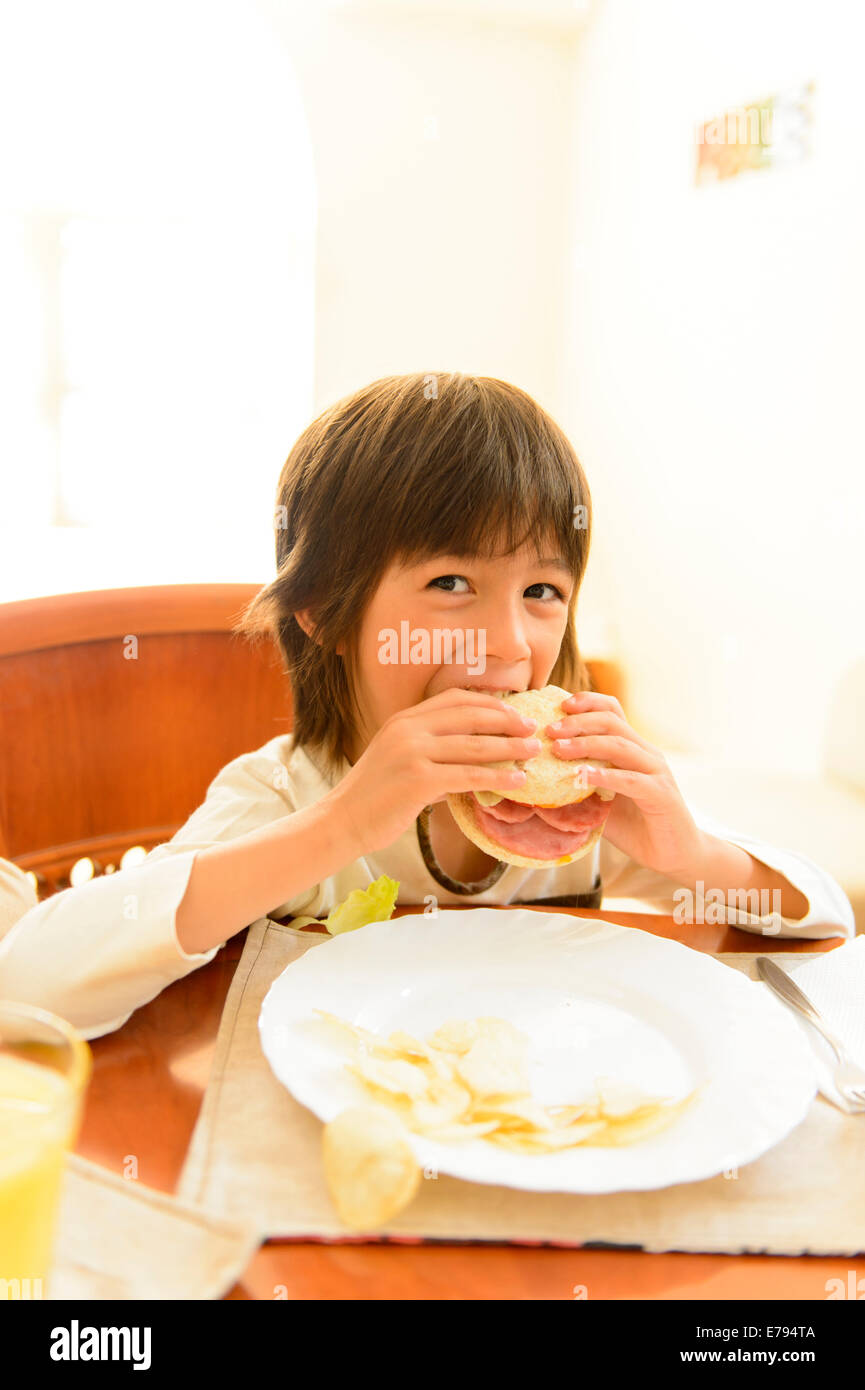 Young boy eating in the kitchen Stock Photo - Alamy